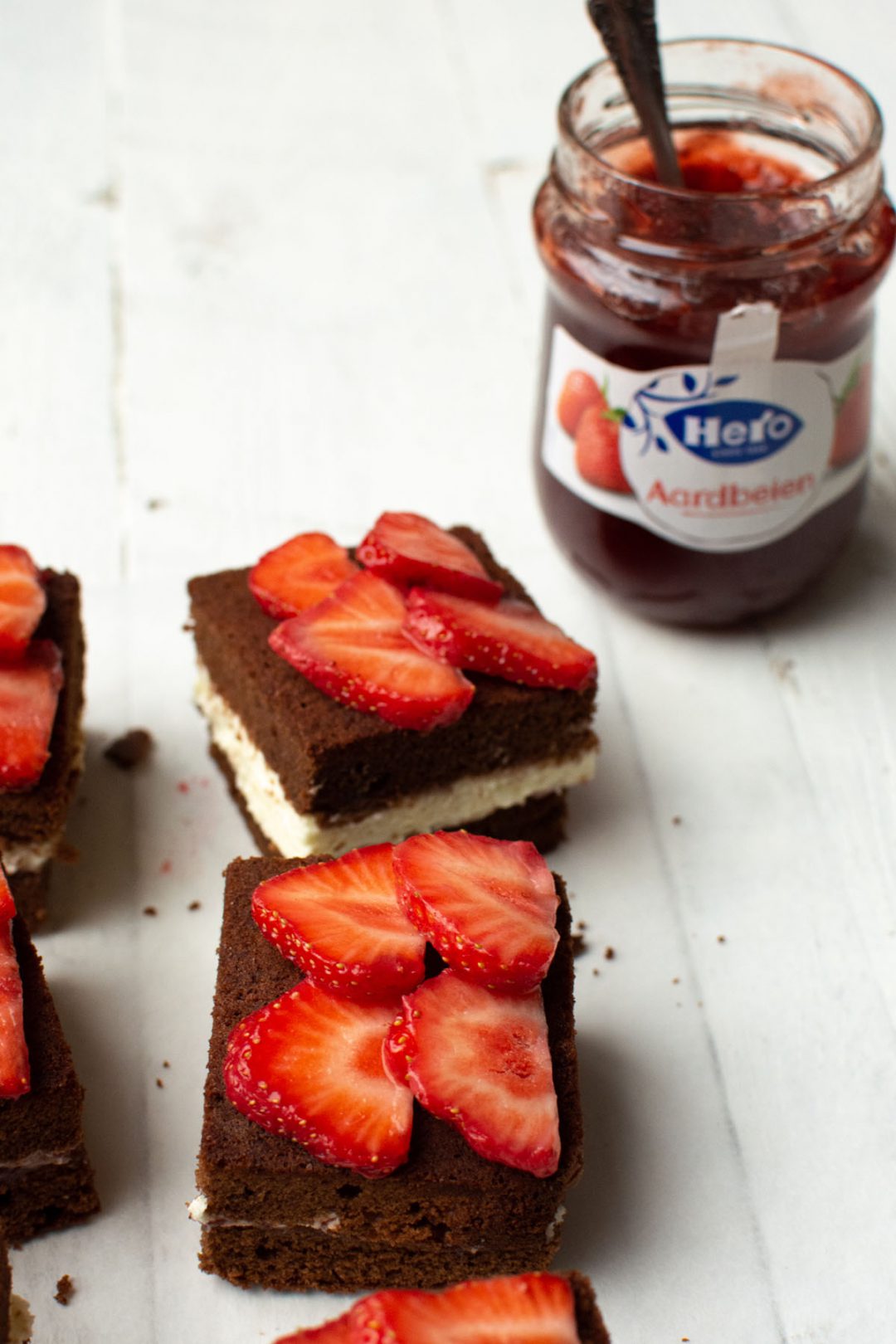 Chocoladecakejes met jam, slagroom en verse aardbeien