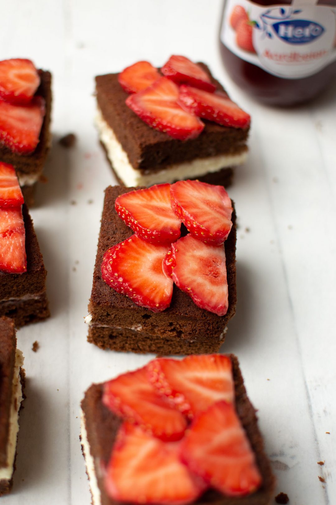 Chocoladecakejes met jam, slagroom en verse aardbeien